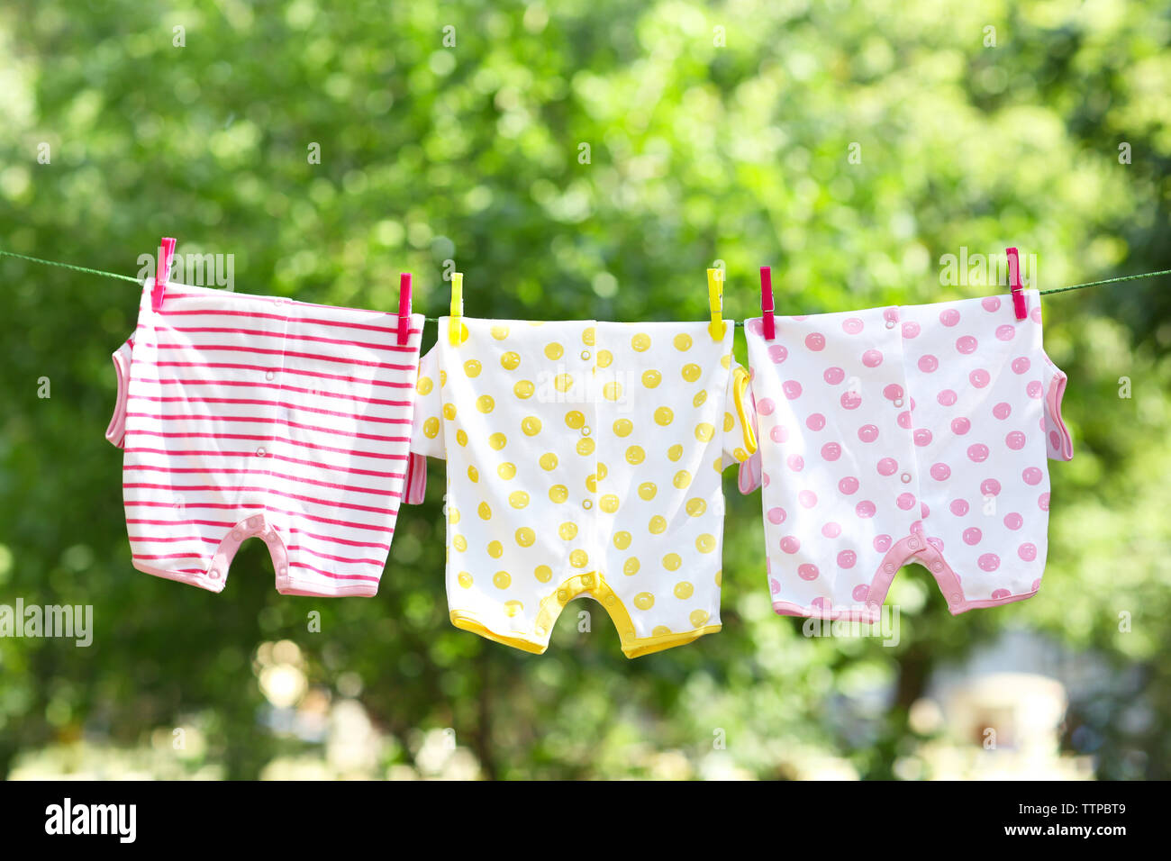 Baby clothes hanging on clothesline Stock Photo - Alamy
