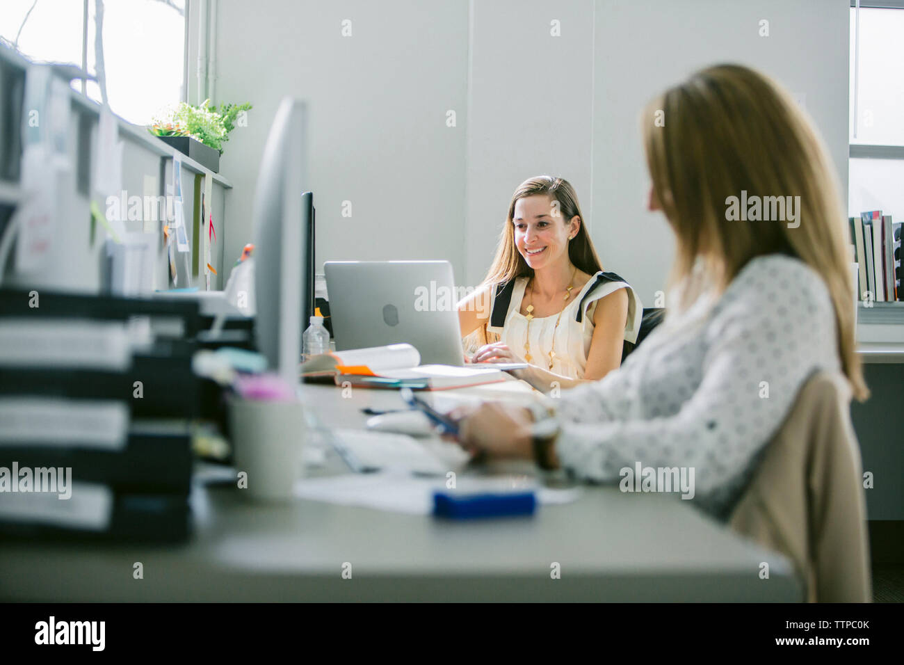 Female colleagues working desk hi-res stock photography and images - Alamy