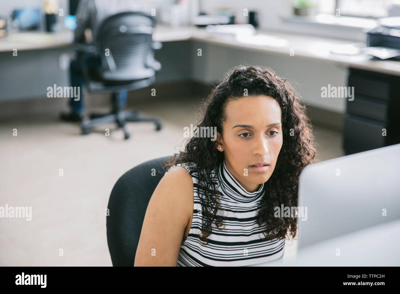 businesswoman using computer while male colleague in background Stock ...