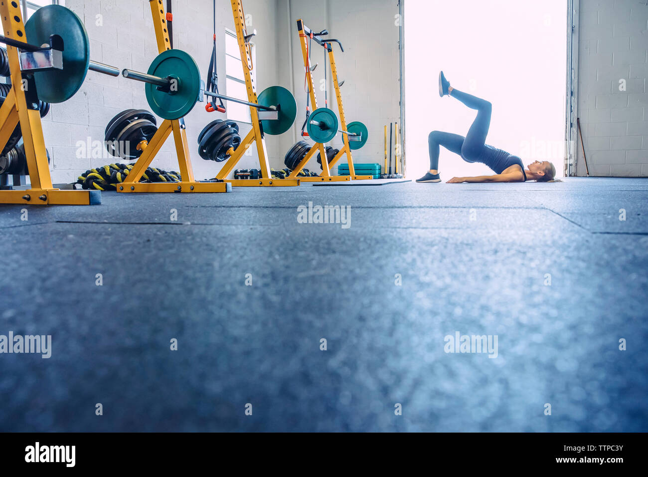Woman exercising while lying down in gym Stock Photo - Alamy