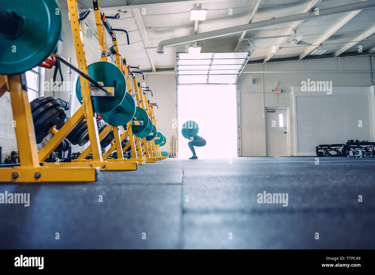 Side view of woman weightlifting while exercising in gym Stock Photo ...
