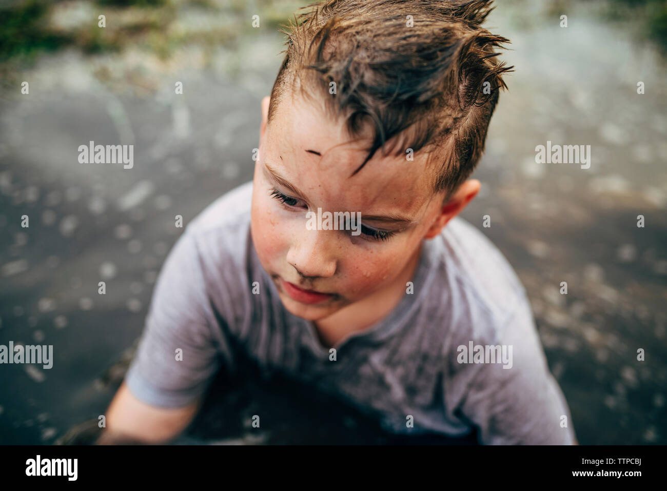 High angle view of messy boy sitting in puddle Stock Photo - Alamy