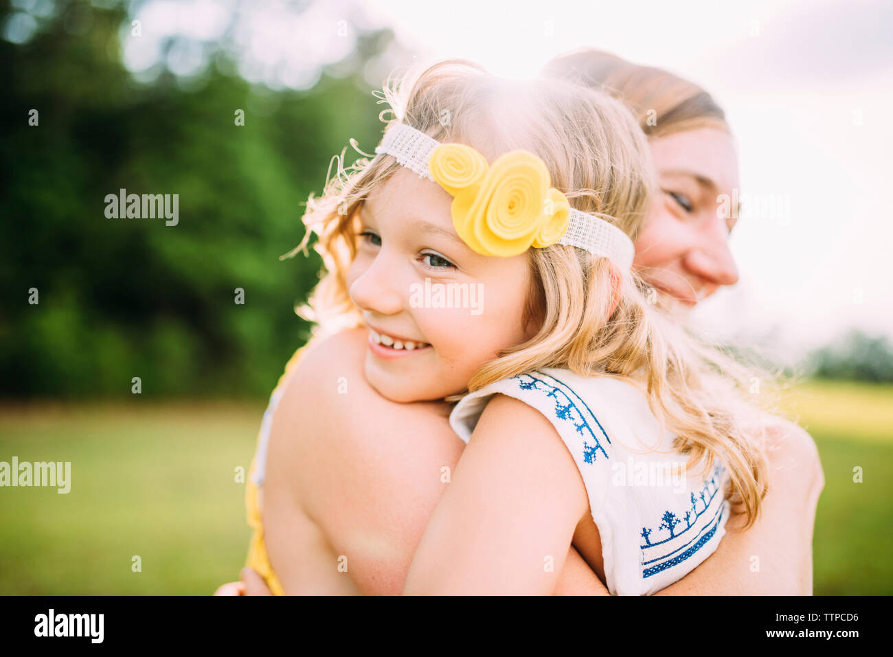 Happy mother and daughter embracing at park Stock Photo - Alamy