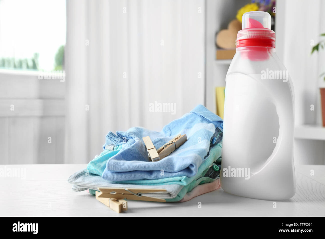 Clean clothes with pins and detergent on table Stock Photo - Alamy