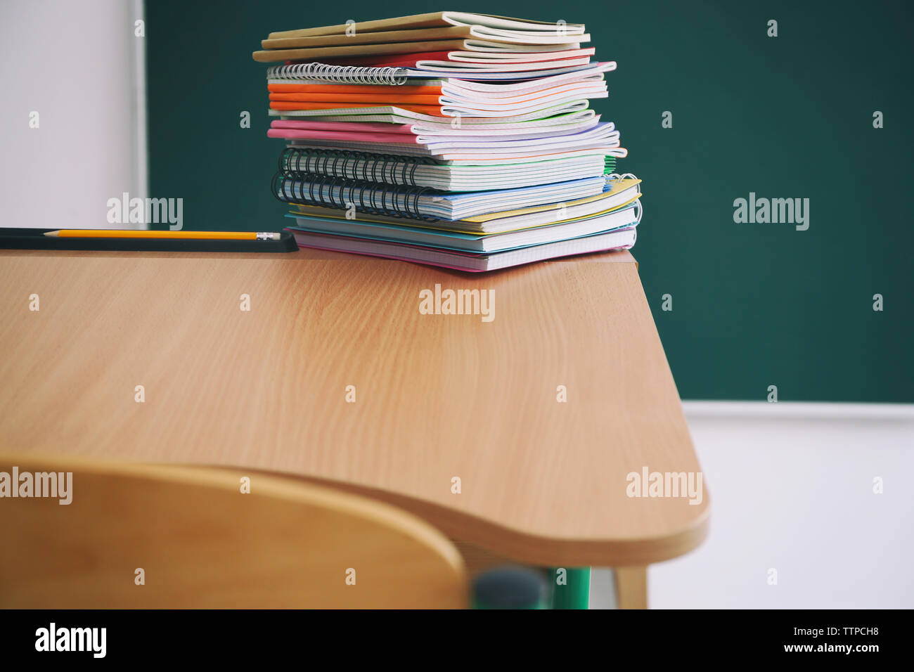 Stacked school notebooks on blackboard background Stock Photo - Alamy