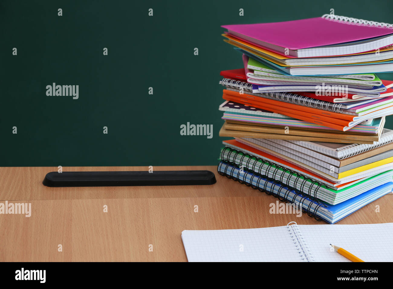 Stacked school notebooks on blackboard background Stock Photo - Alamy