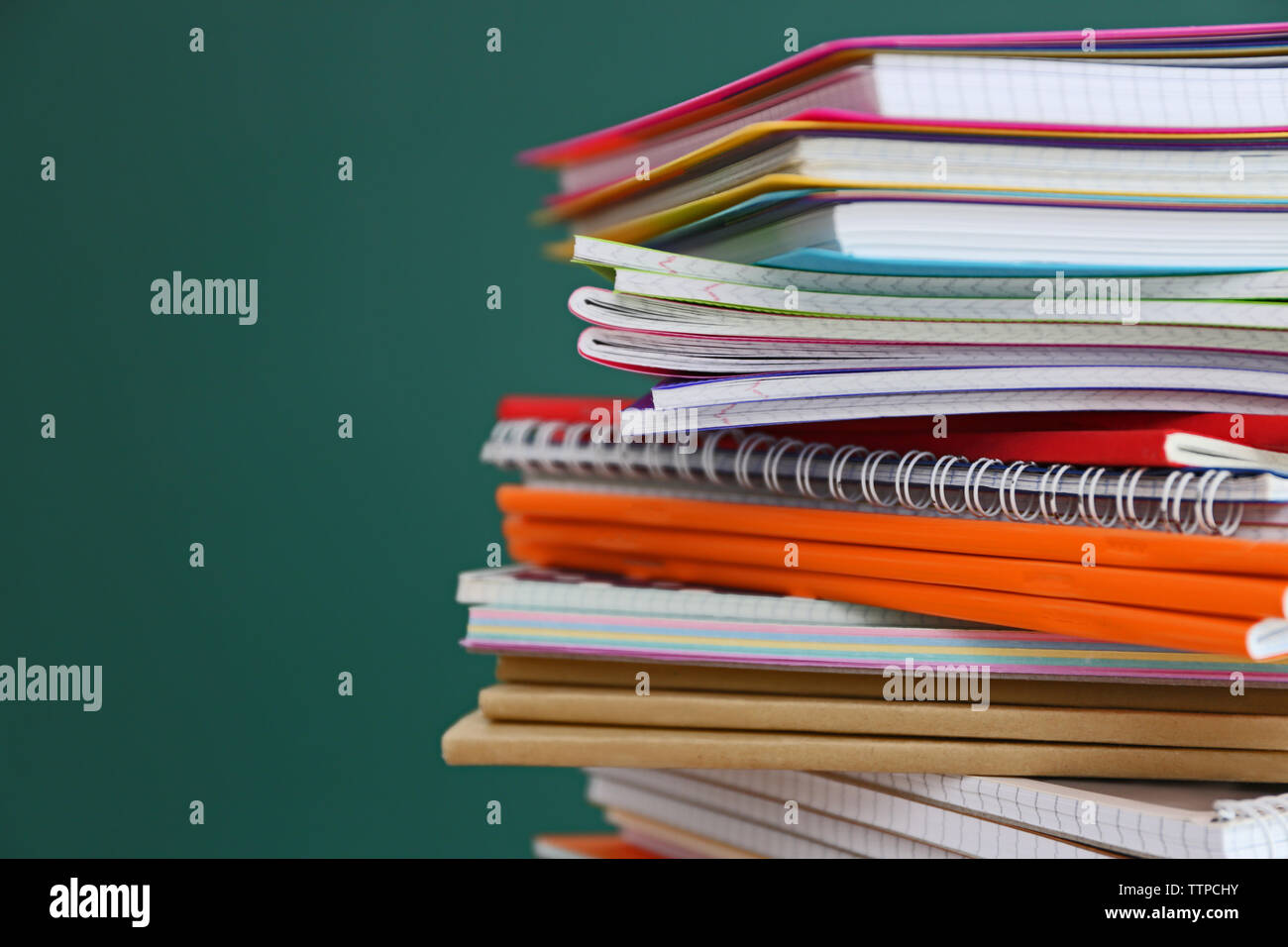 Stacked school notebooks on blackboard background Stock Photo - Alamy
