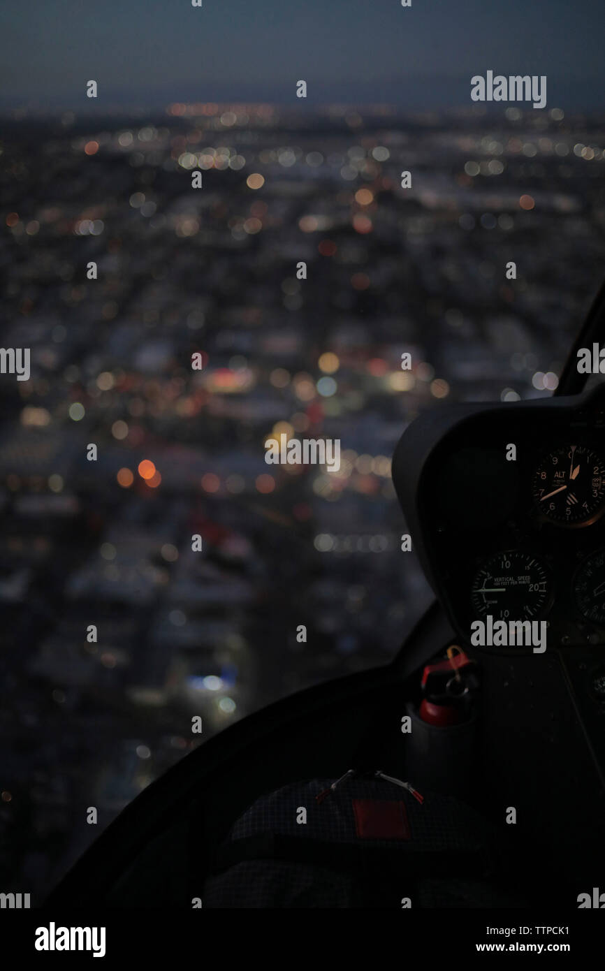 Illuminated cityscape seen through helicopter's windshield at night ...