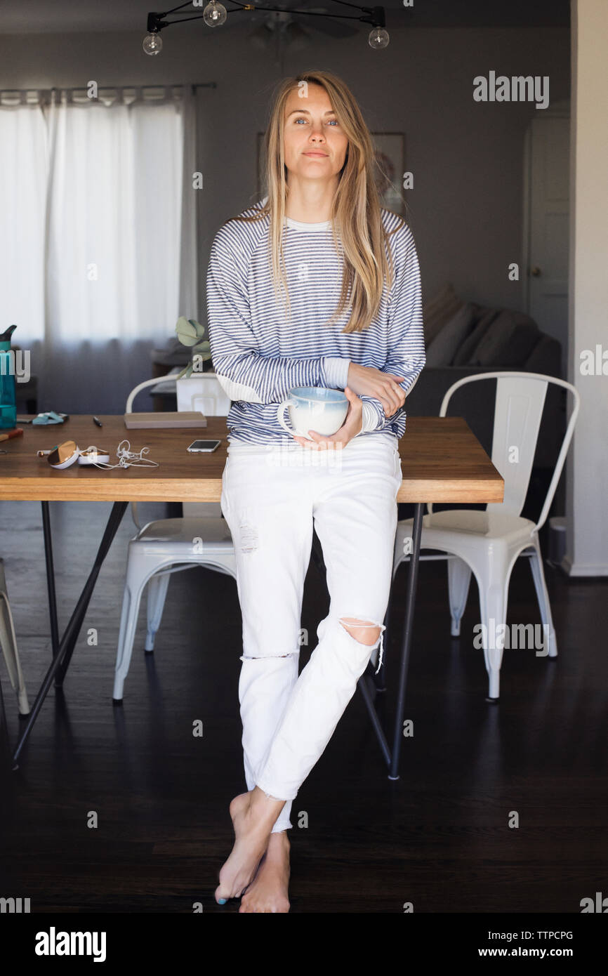 Portrait of confident woman standing at home Stock Photo - Alamy