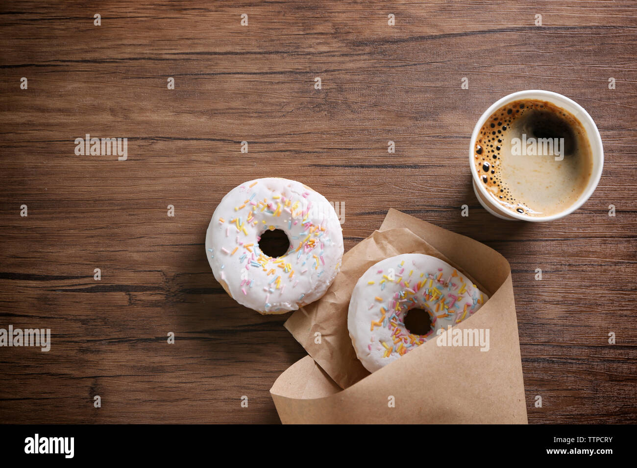 Paper cup of coffee and doughnuts on wooden background Stock Photo - Alamy