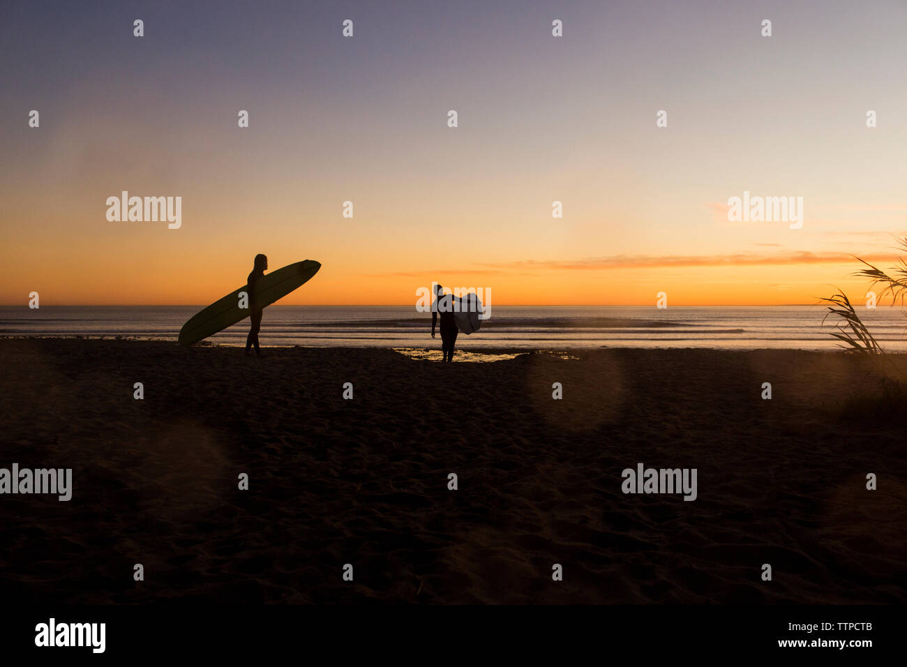 Couple Carrying Surfboards While Walking On San Onofre State Beach