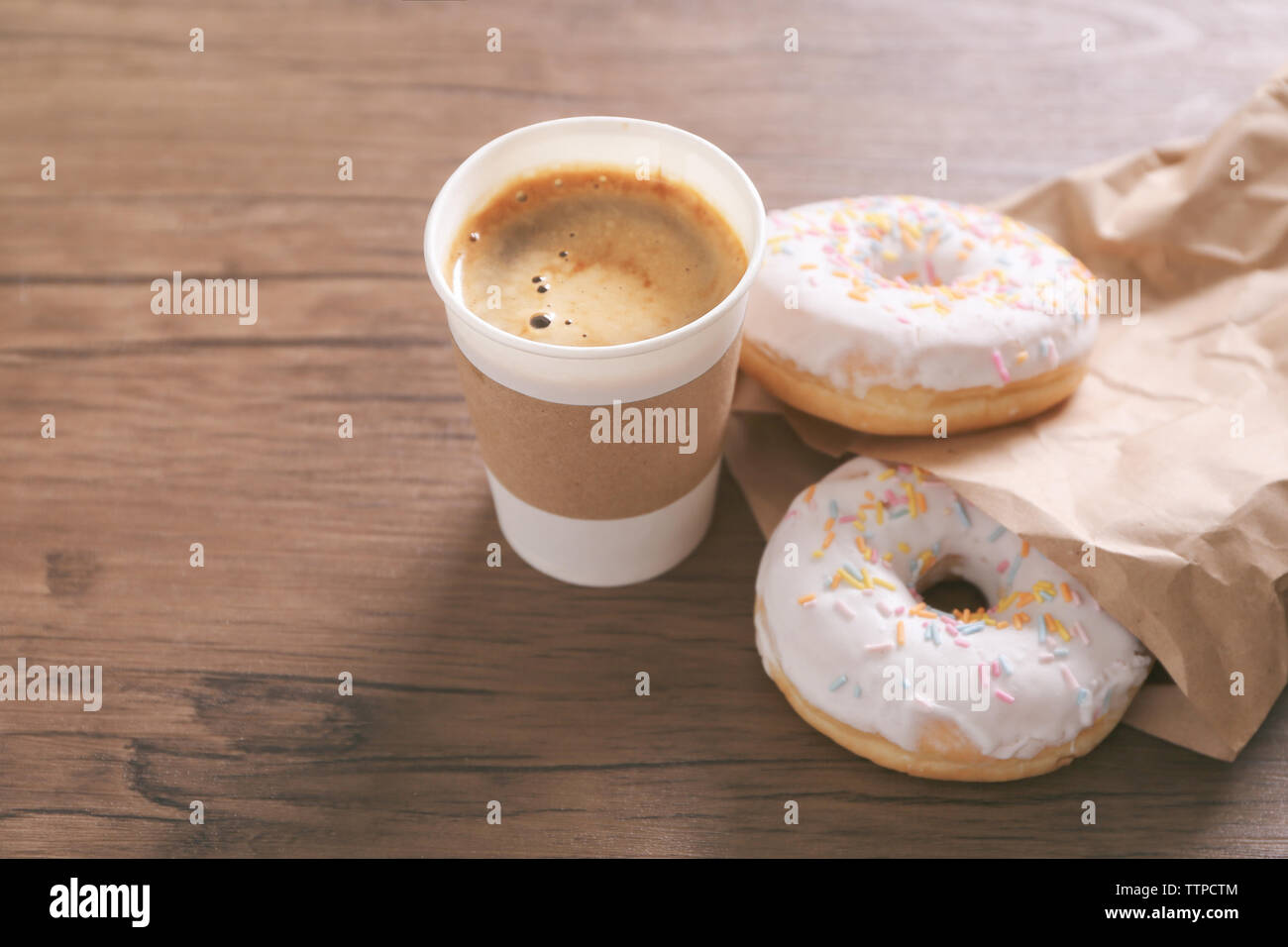 Paper cup of coffee and doughnuts on wooden background Stock Photo - Alamy