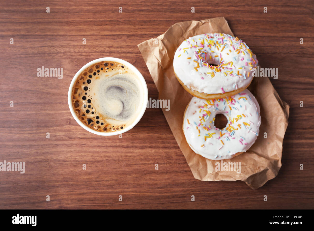 Paper cup of coffee and doughnuts on wooden background Stock Photo - Alamy