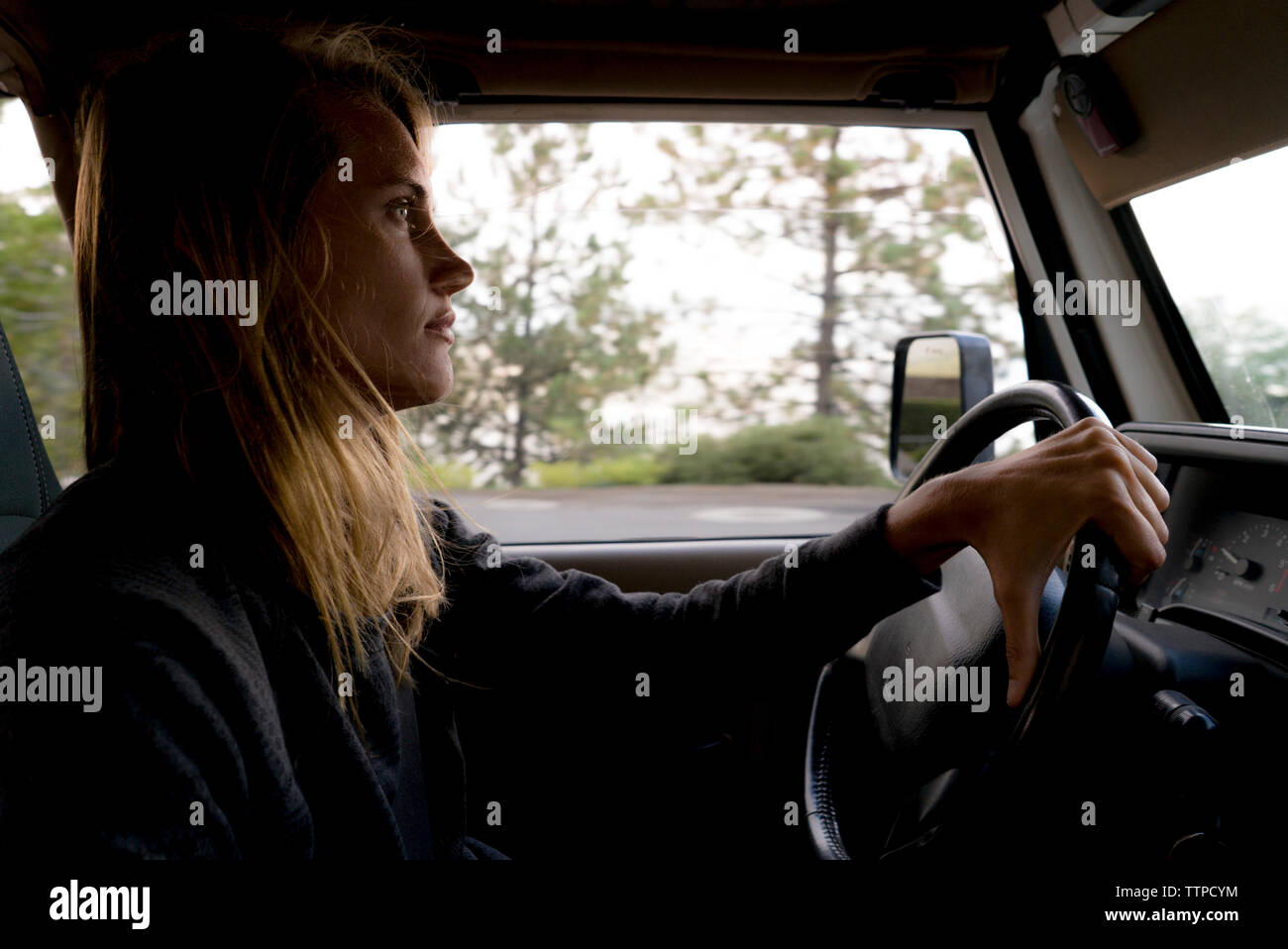 Side view of woman driving car Stock Photo - Alamy