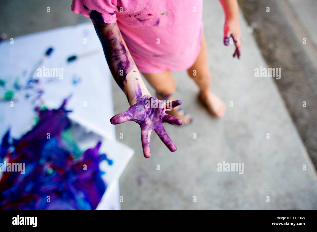 Low section of girl with messy hand standing on floor at home Stock ...