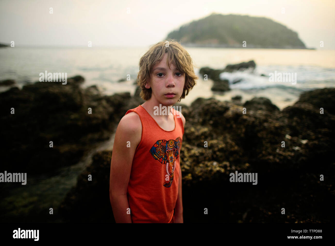 Portrait of boy standing against sea during sunset Stock Photo - Alamy