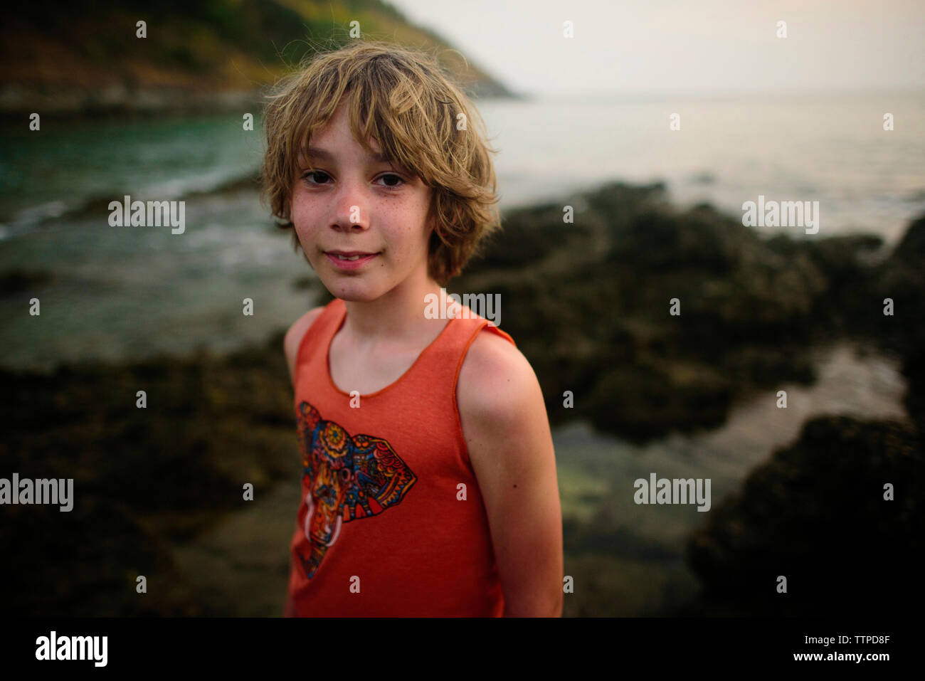 Portrait of boy standing against sea Stock Photo - Alamy