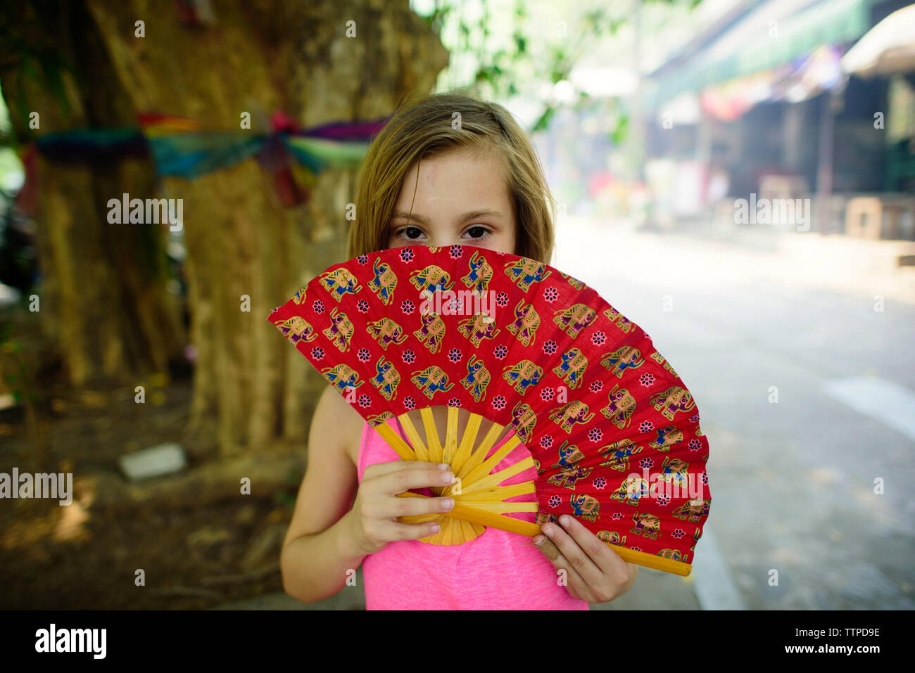 Portrait of girl holding folding fan Stock Photo - Alamy
