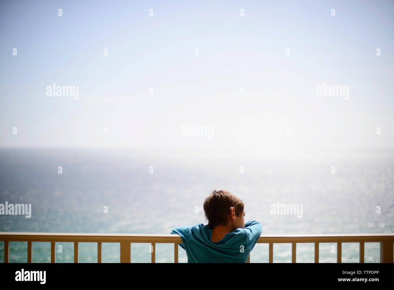 Boy leaning railing outdoors hi-res stock photography and images - Alamy