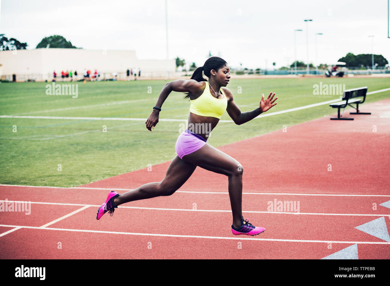 Side view of determined female athlete running on tracks Stock Photo ...