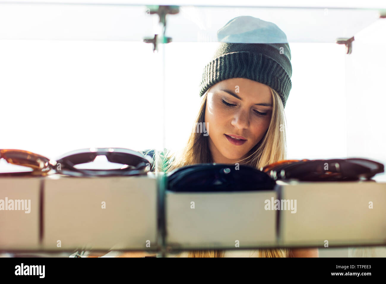 Young woman window shopping outside sunglasses store Stock Photo - Alamy