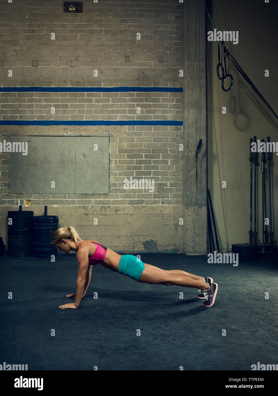 Side view of female athlete doing push-ups at gym Stock Photo - Alamy