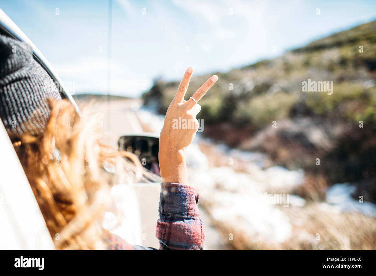 Rear view of woman gesturing peace sign while sitting in car Stock ...