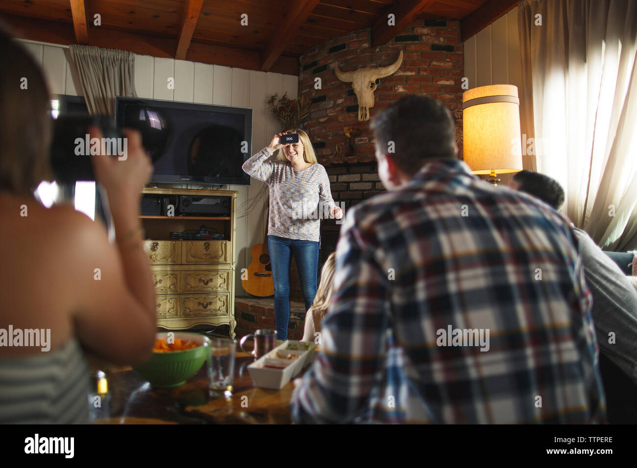 Friends playing heads up game during social gathering at home Stock ...