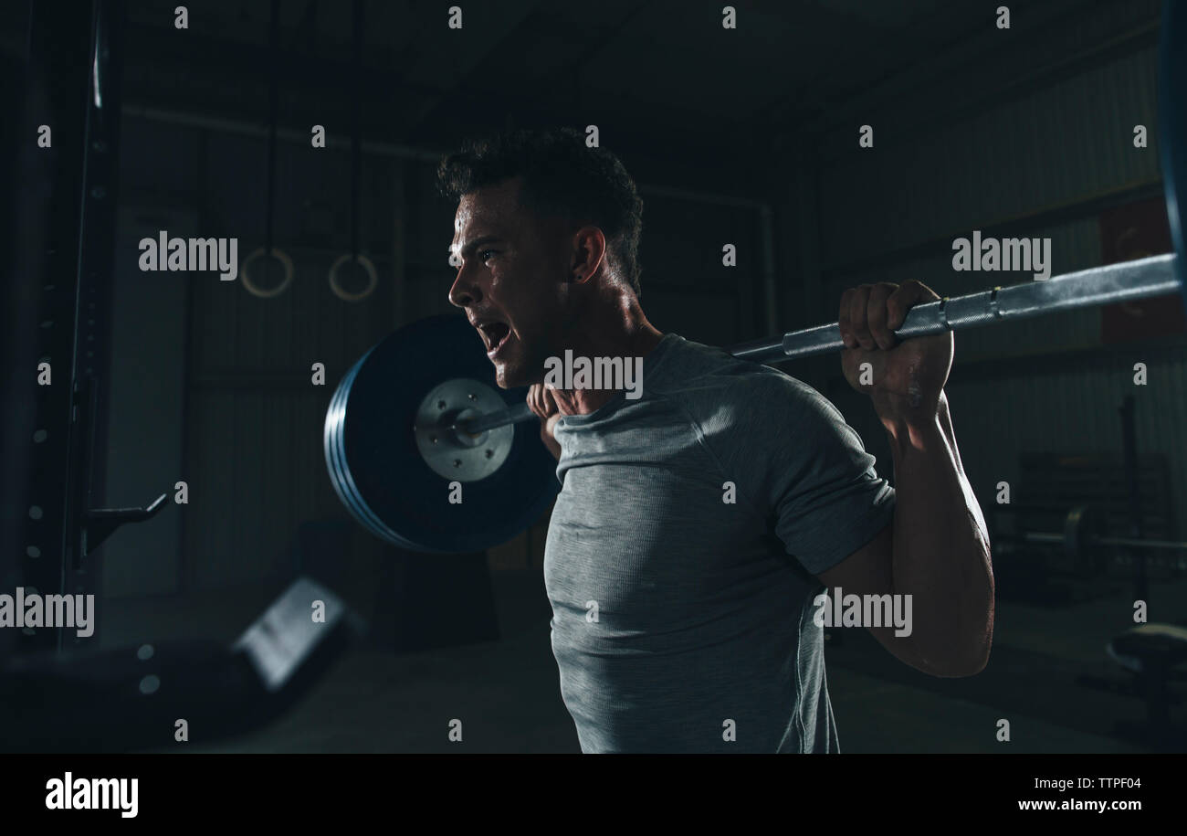 Athlete screaming while lifting barbell in gym Stock Photo - Alamy