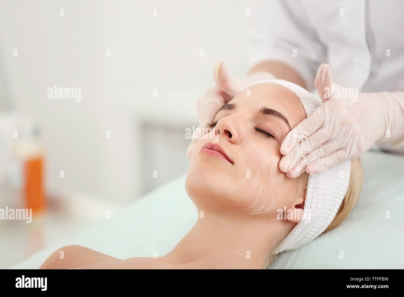 Cosmetologist applying cream on female face Stock Photo - Alamy