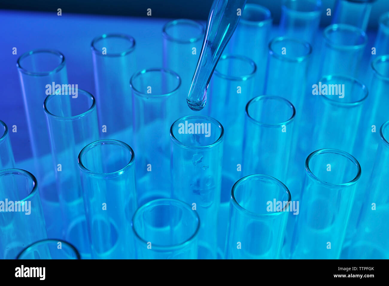 Close up of a pipette dropping sample into a test tube Stock Photo - Alamy