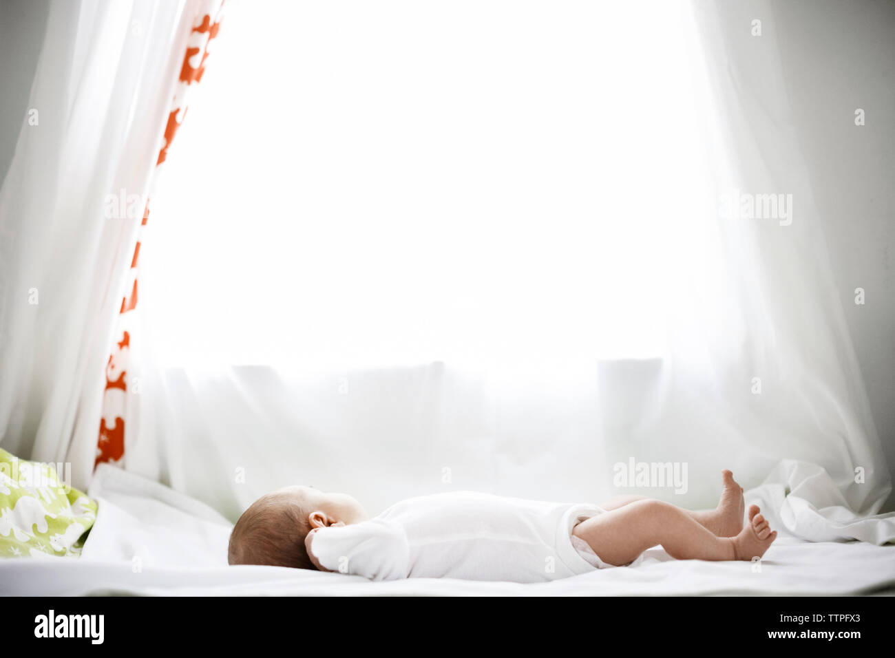 Side view of baby girl sleeping on bed at home Stock Photo - Alamy