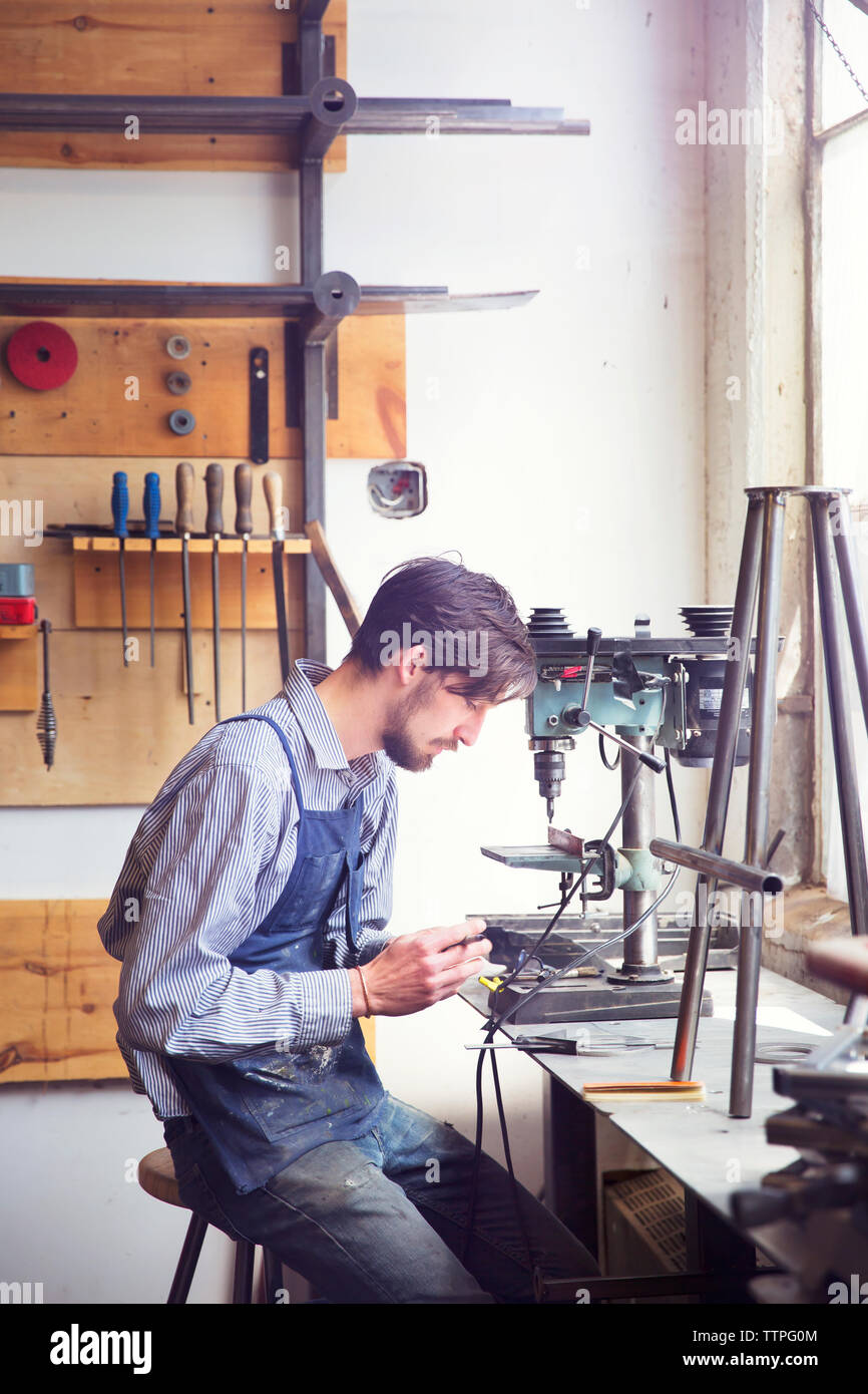 Male craftsperson working on machinery at wood shop Stock Photo - Alamy