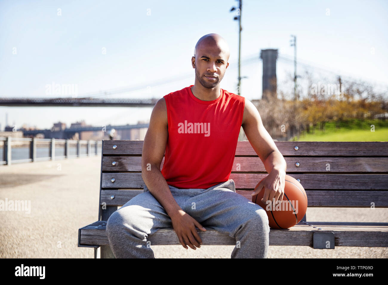 Portrait of basketball player sitting on bench at promenade Stock Photo ...