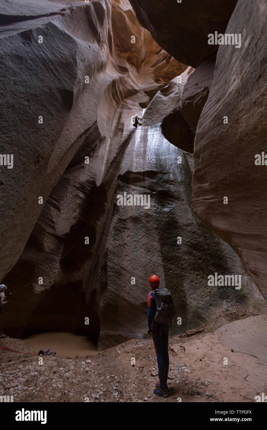 Male backpacker standing amidst rock formation Stock Photo - Alamy