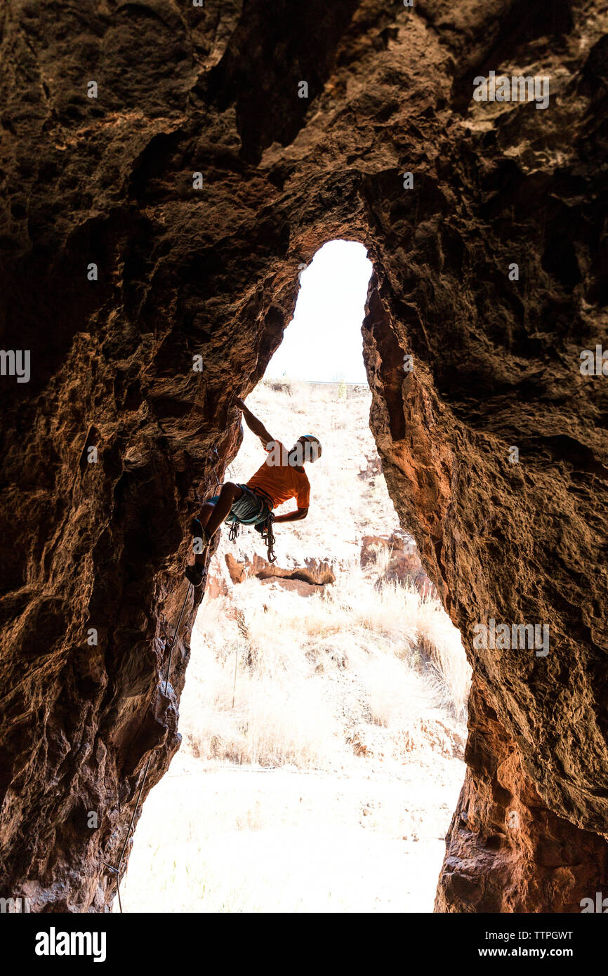 Hiker climbing rock formation at desert Stock Photo - Alamy