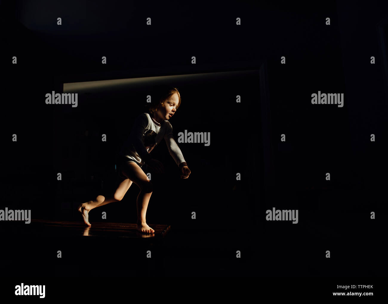 Boy running in dark room at home Stock Photo - Alamy