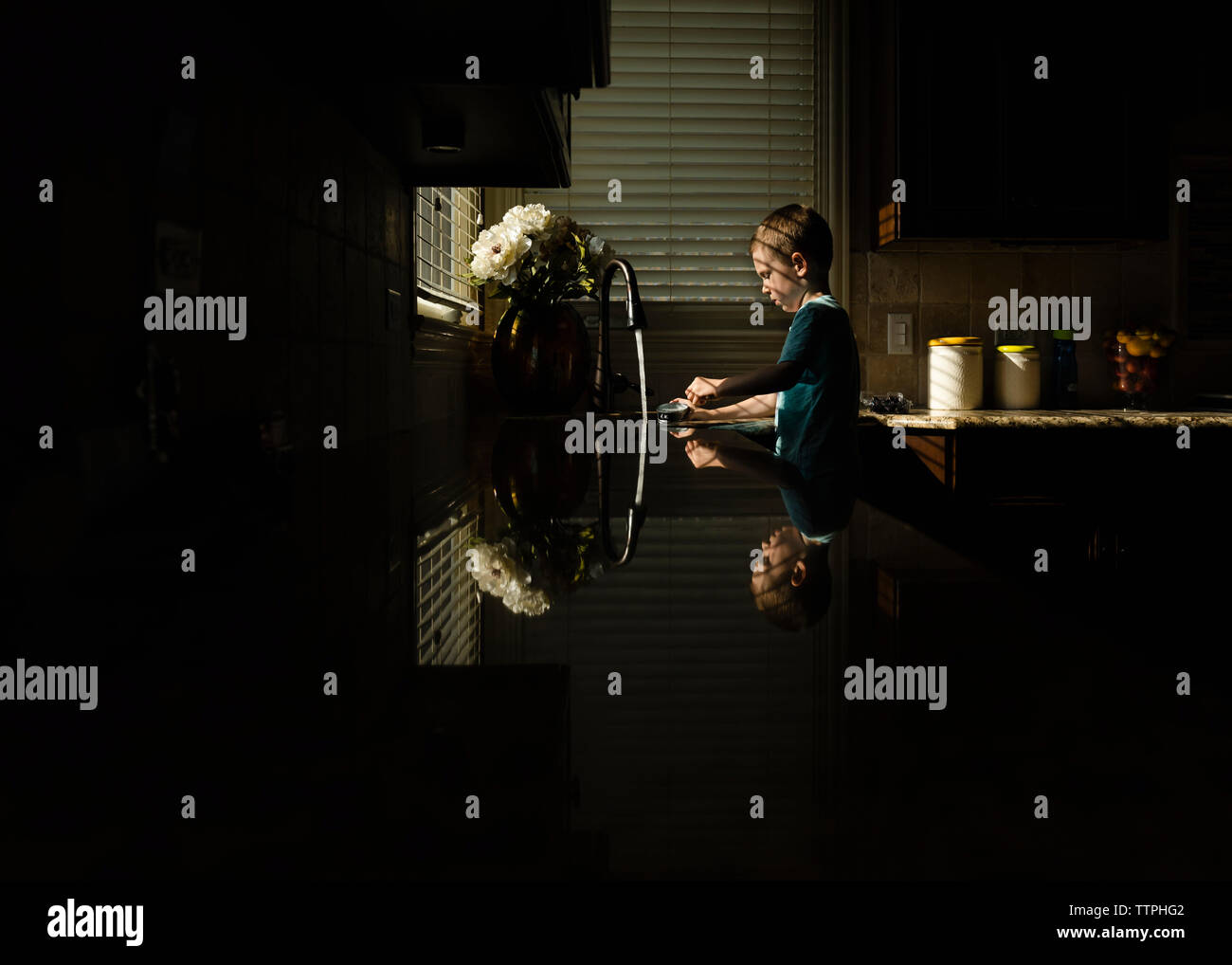 Boy washing container in kitchen at home Stock Photo - Alamy