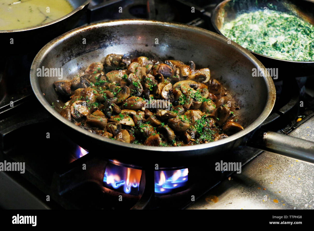 saute mushrooms in a frying pan on fire Stock Photo - Alamy