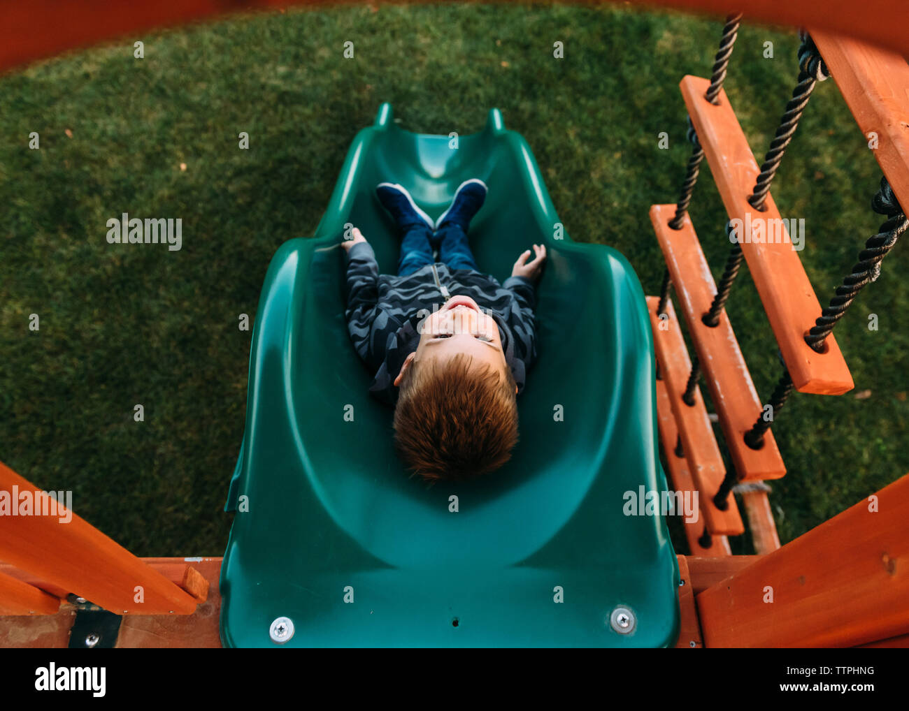 Boy sliding down slide hi-res stock photography and images - Alamy