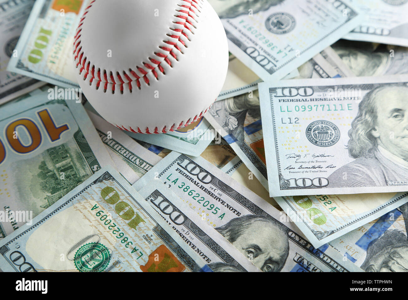 Baseball ball on money bills Stock Photo - Alamy
