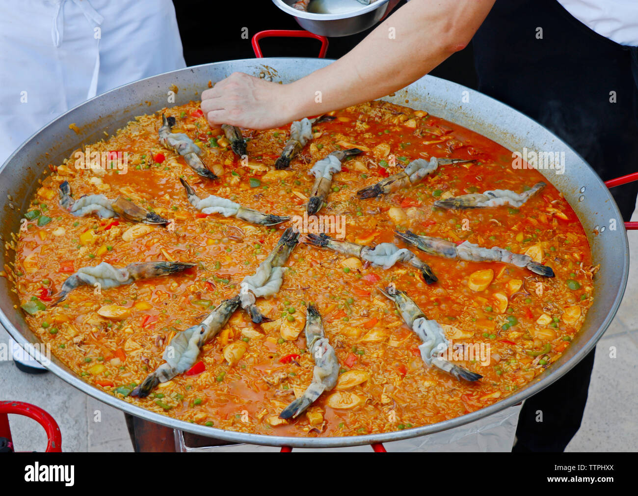 Spanish seafood paella outdoor cooking by a chef Stock Photo - Alamy