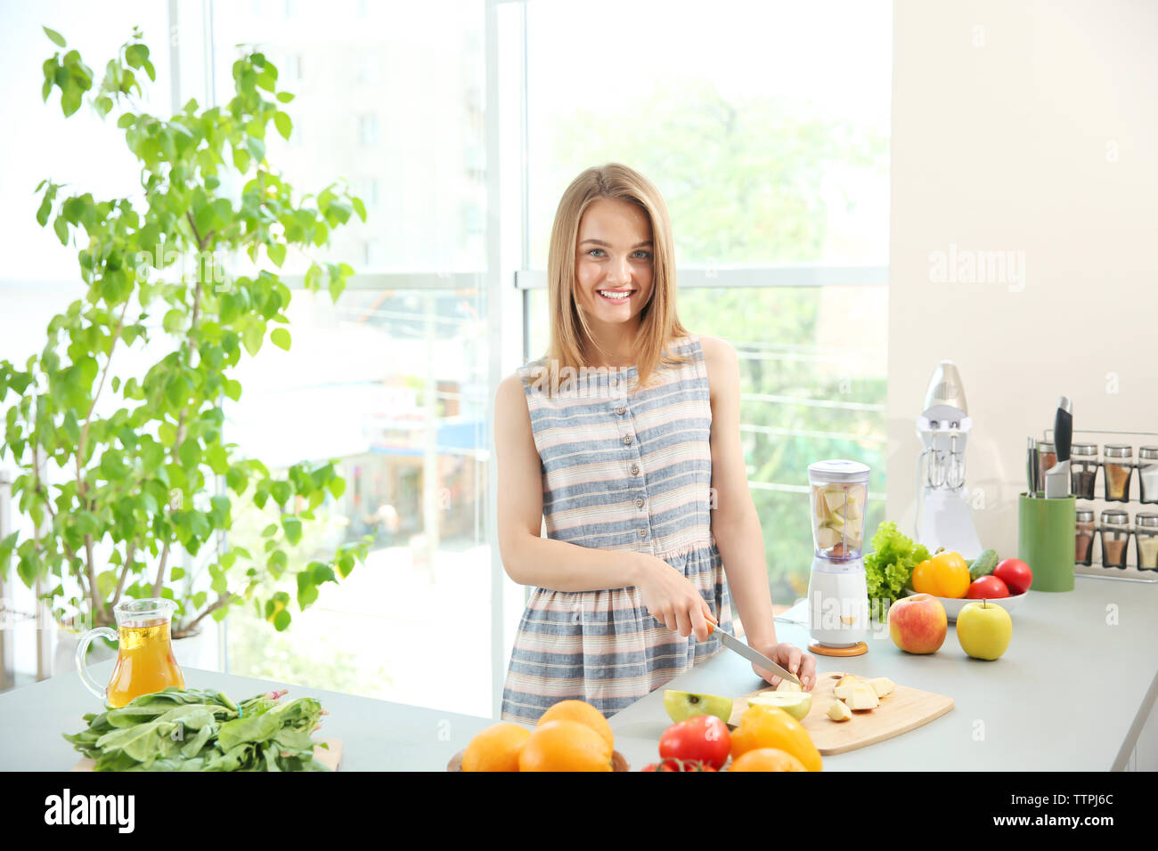 Attractive young woman cutting fruit hi-res stock photography and ...