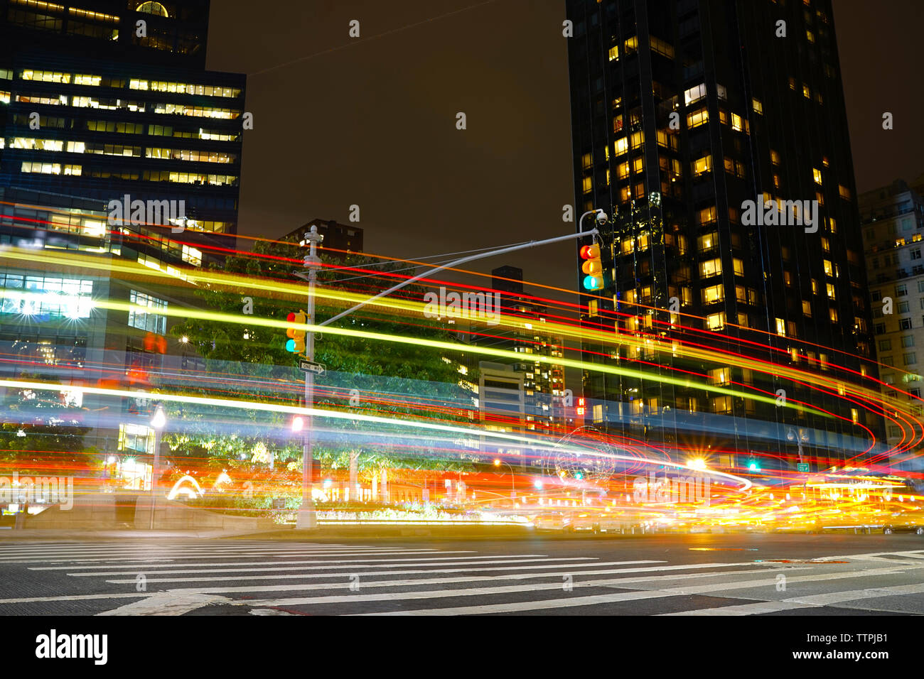 Light trails on city street by illuminated buildings Stock Photo - Alamy