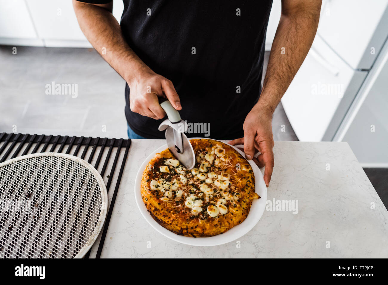 Overhead shot of man slicing pizza Stock Photo - Alamy