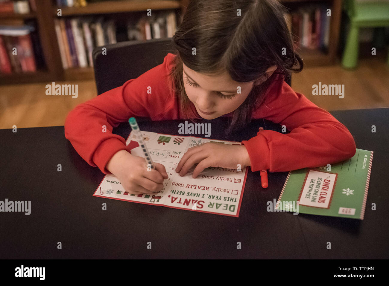 Cute Girl Writing Letter To Santa Claus At Home During Christmas Stock cute-girl-writing-letter-to-santa-claus-at-home-during-christmas-stock