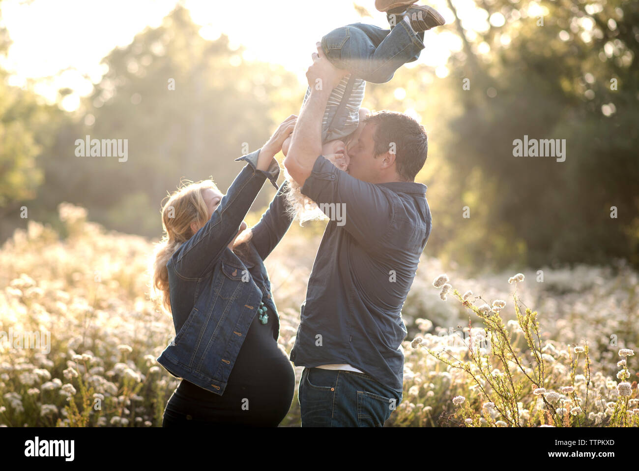 Side view of happy family on field during sunny day Stock Photo - Alamy