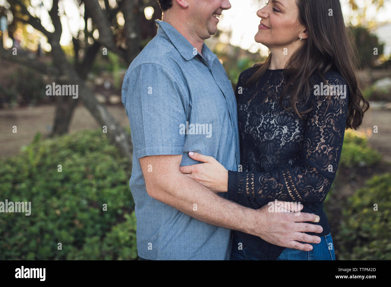 Side view of loving couple standing face to face at park Stock Photo ...