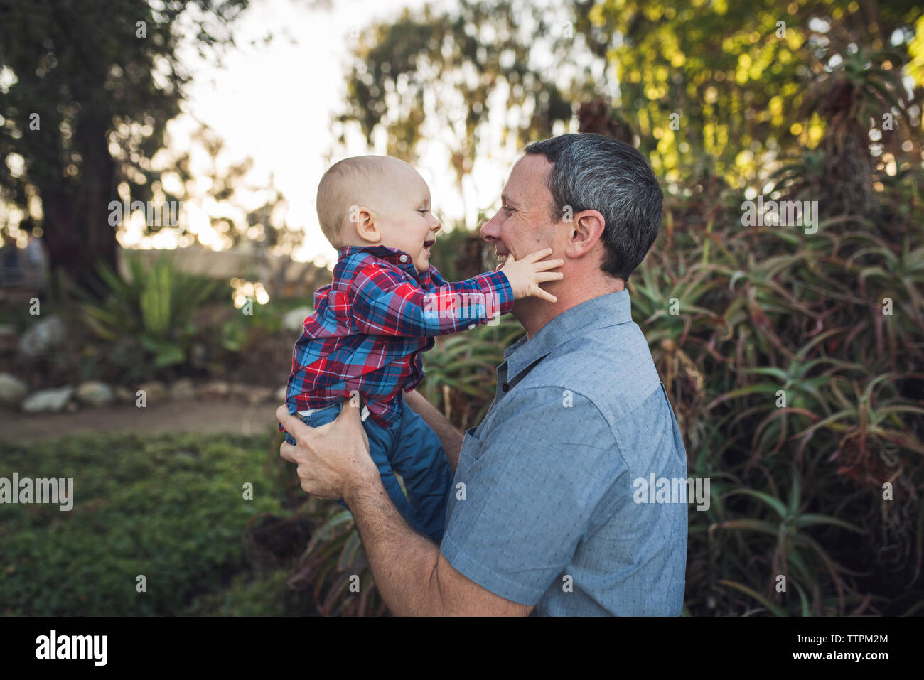Side view of father and son playing at park Stock Photo - Alamy