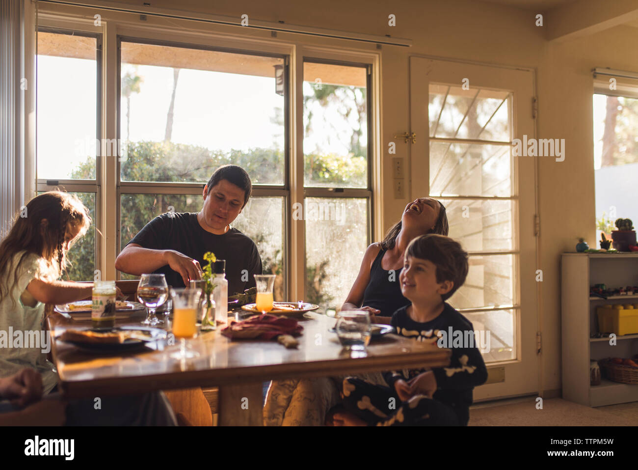 Happy family having breakfast at dining table Stock Photo - Alamy